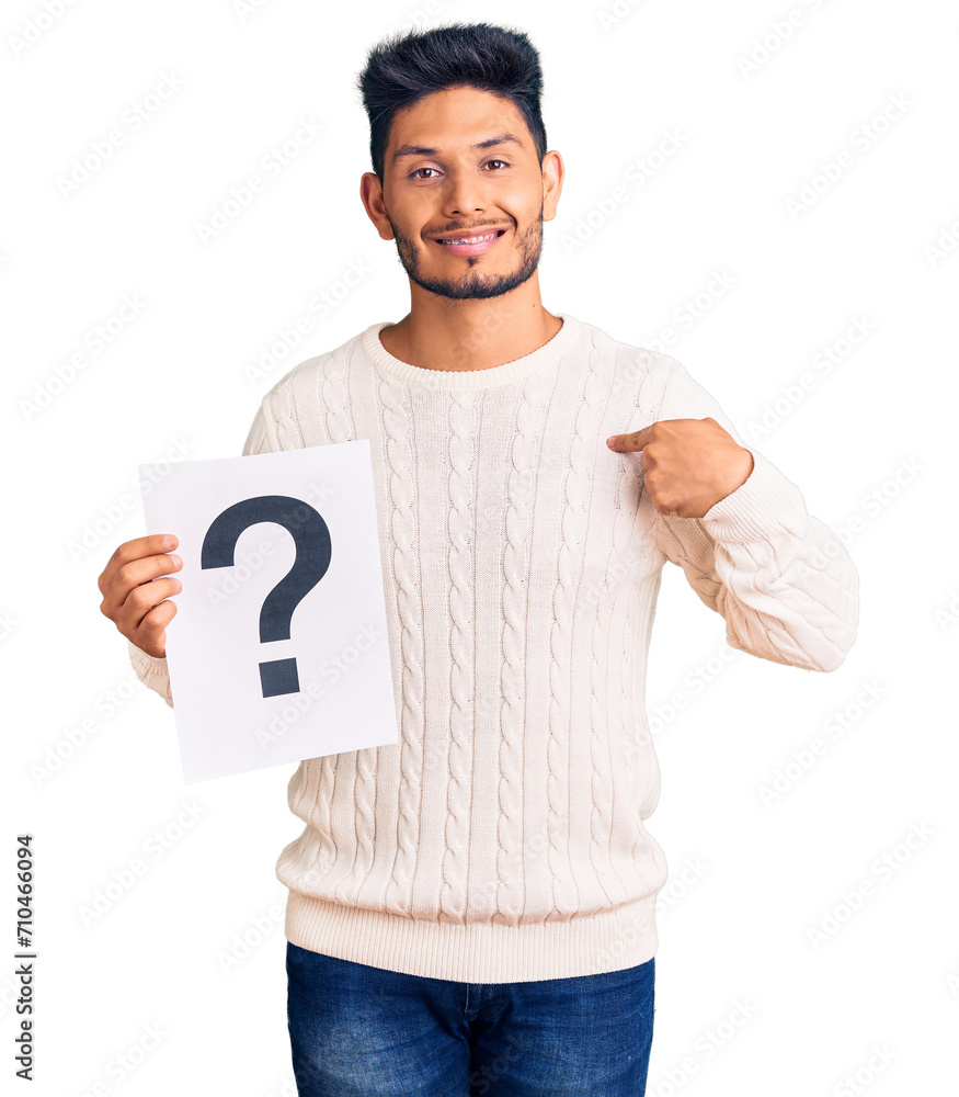 Handsome latin american young man holding question mark pointing finger ...