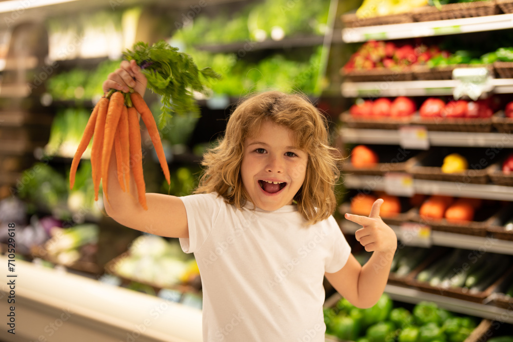 Excited Child choosing fruits and vegetables in food store. Kids in fruits and vegetables market ...