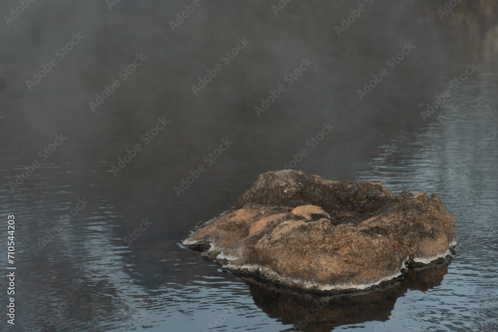 Rocks protruding above the surface of the water in chaeson Hot Spring ...