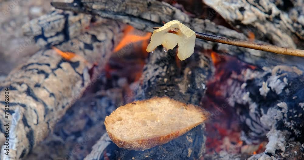 fried bacon with a slice of toasted bread an open fire in nature ...