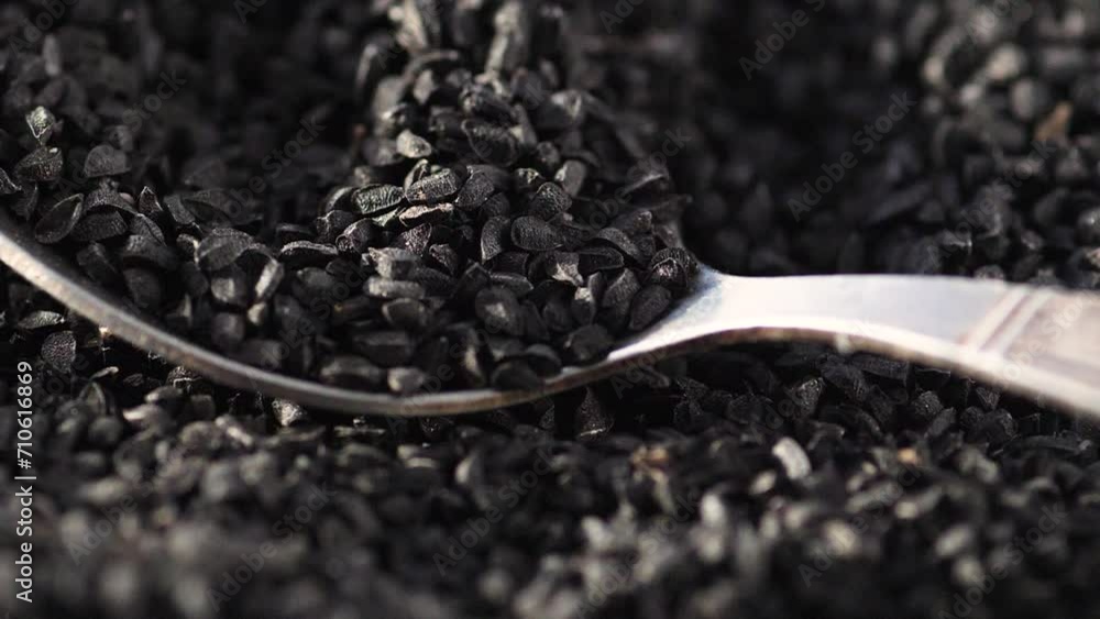 Vidéo Stock macro black cumin seeds falling on a spoon. slow motion ...