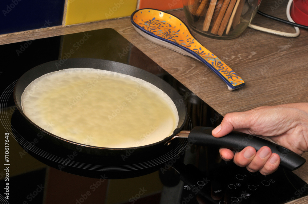 Cuire une crêpe dans une crêpière sur une plaque de cuisson en gros ...