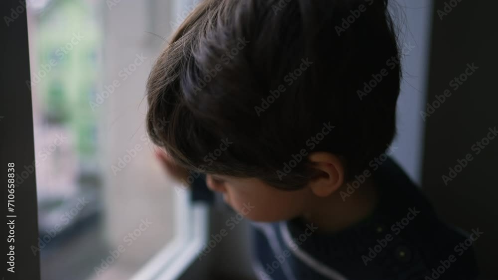 Vidéo Stock Little boy leaning on window looking out. Child confined ...