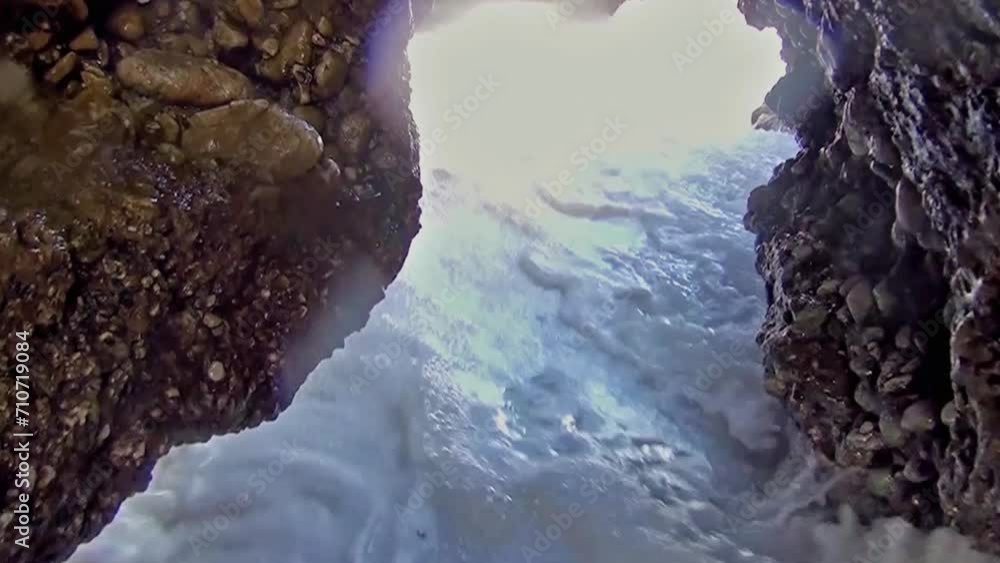 Camera quickly retreating between rocks in cliff tunnel due to the ...