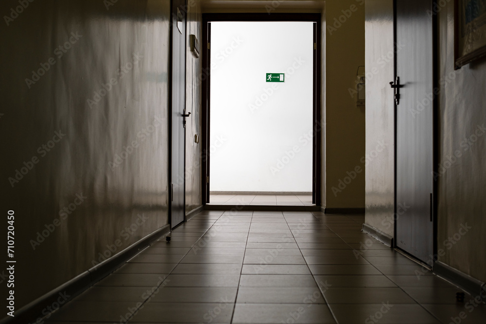 A long dark corridor with a bright hall. There is no one, the ...