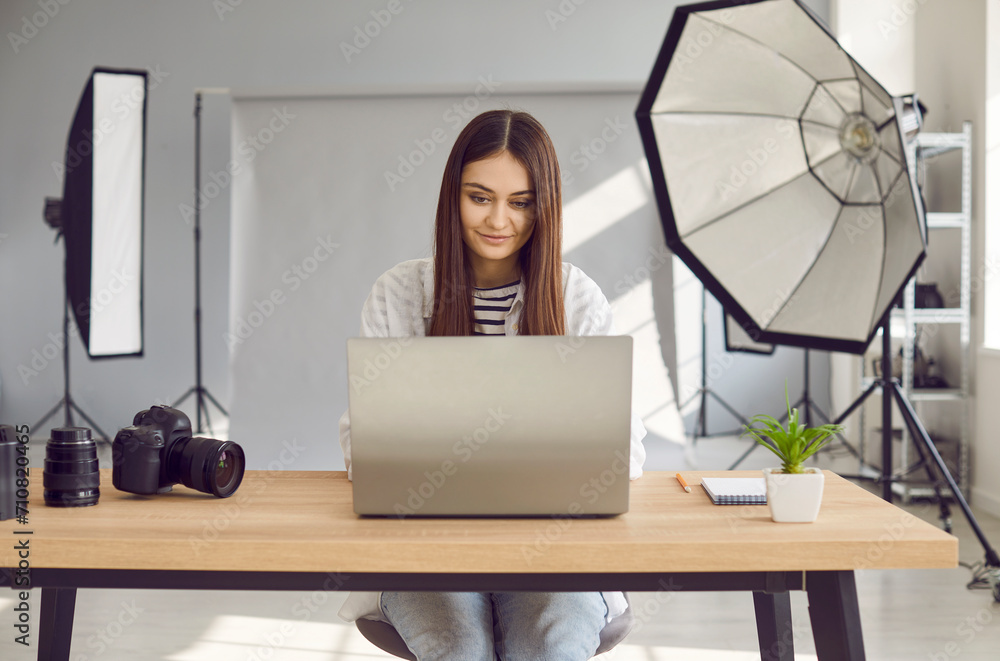 Beautiful woman photographer editing photos on laptop computer in ...