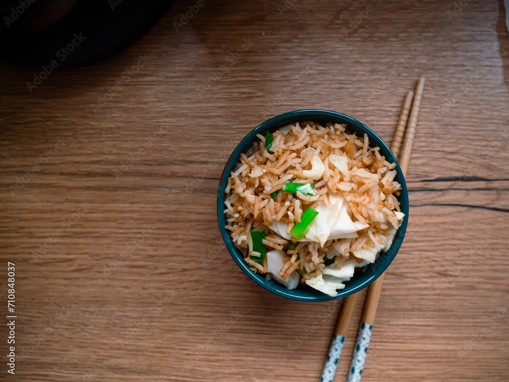 Petit bol de riz sautées avec de l'oignon vert et du chou posé sur un ...