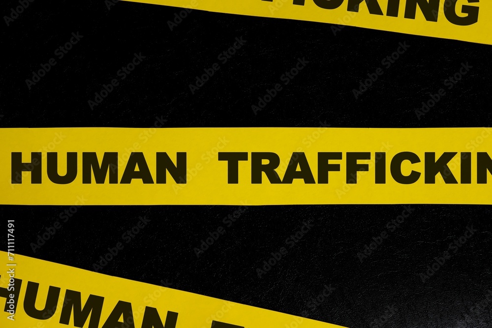 Human trafficking caution and warning concept. Yellow barricade tape ...