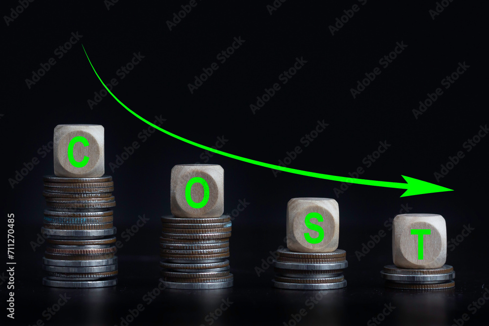 Stacks of coins arranged in steps, with the text Cost on a wooden block ...