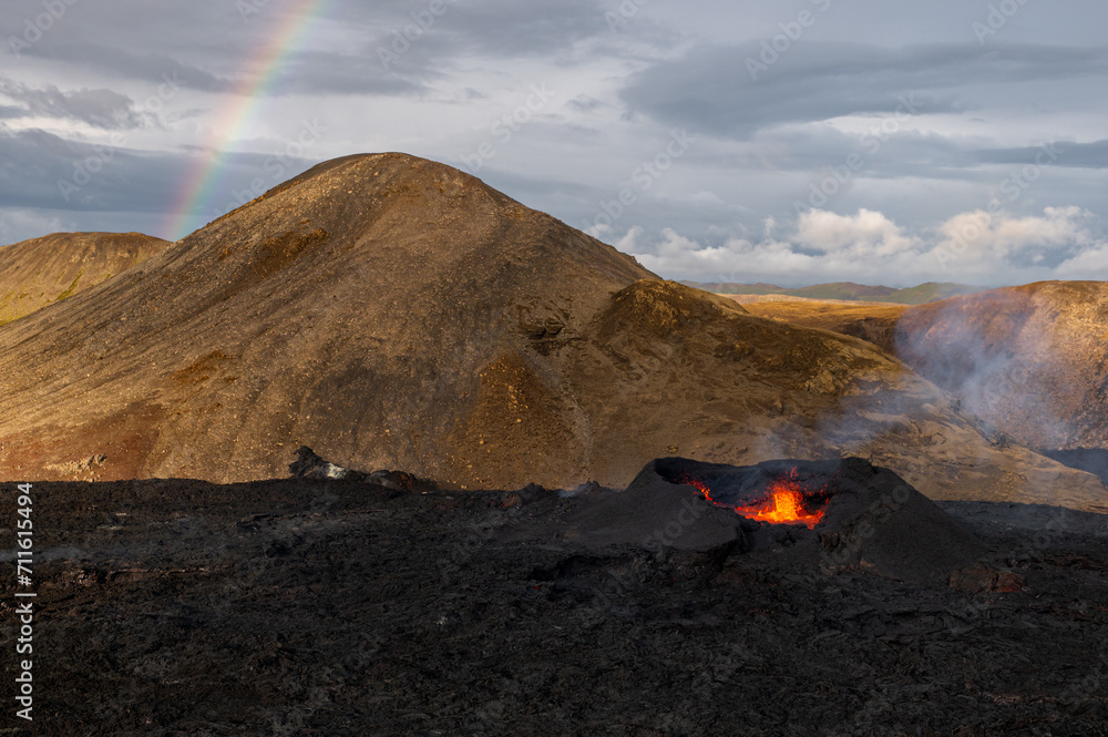 Crater of the erupting volcano with a rainbow. Active Volcano eruption ...
