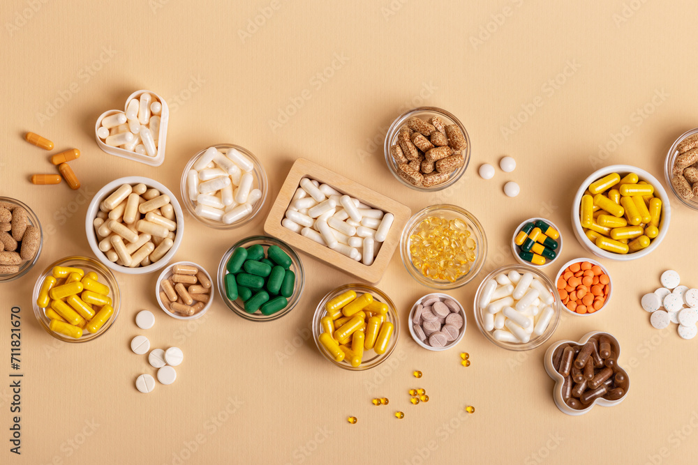 Many different colored vitamins, food supplements and minerals in glass ...