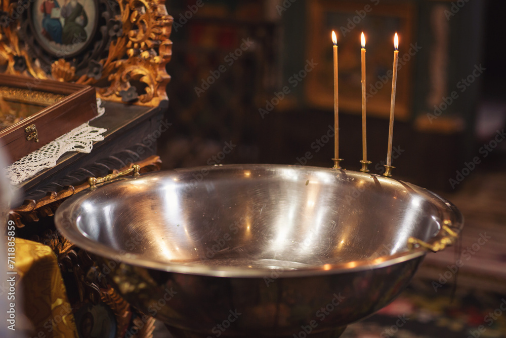 Metal basin (font) with three candles for bathing babies during the ...