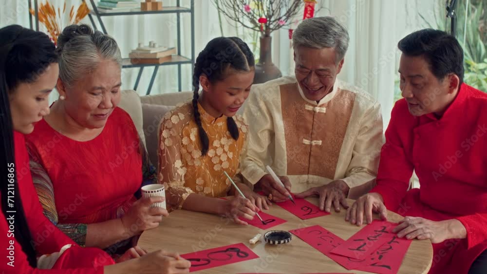 Medium shot of Vietnamese family teaching teenage girl traditional ...
