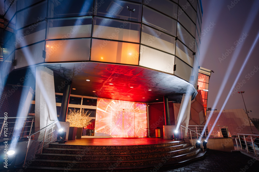 outdoor stage at night with a glowing red LED backdrop and decorative ...
