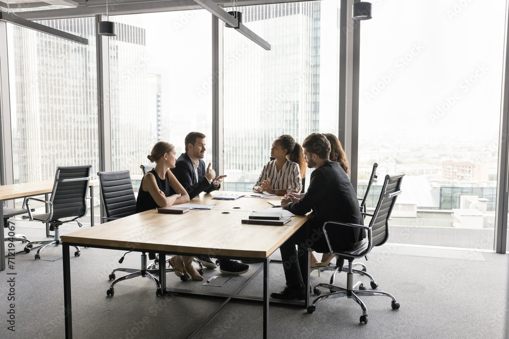Multiethnic business team working on project, talking at table in ...