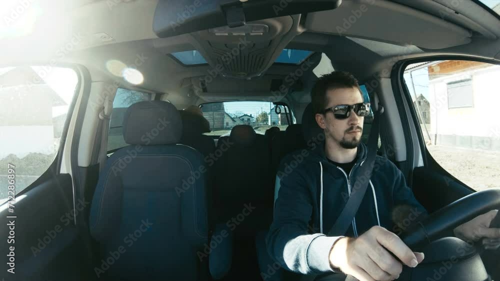 Male driver behind the wheel in car wide shot 4K. Camera on car ...
