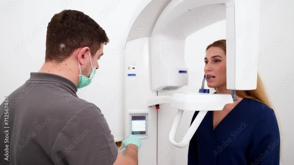 Male radiologist taking teeth x-ray of female patient using dental x ...