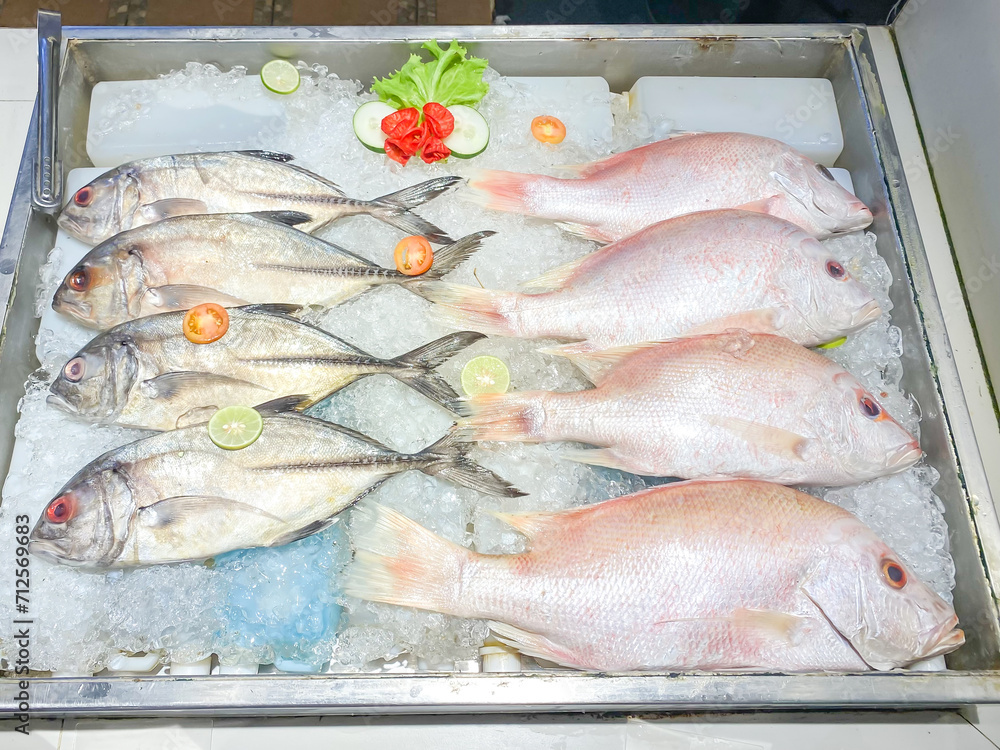 Fresh frozen red snapper and giant trevally fish with ice sold at a ...