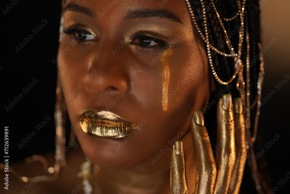 Portrait of an African-American woman with gold jewelry in her hair ...
