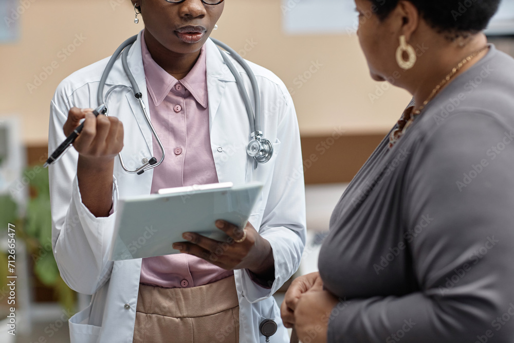 Cropped shot of Black woman general practitioner wearing lab coat with ...