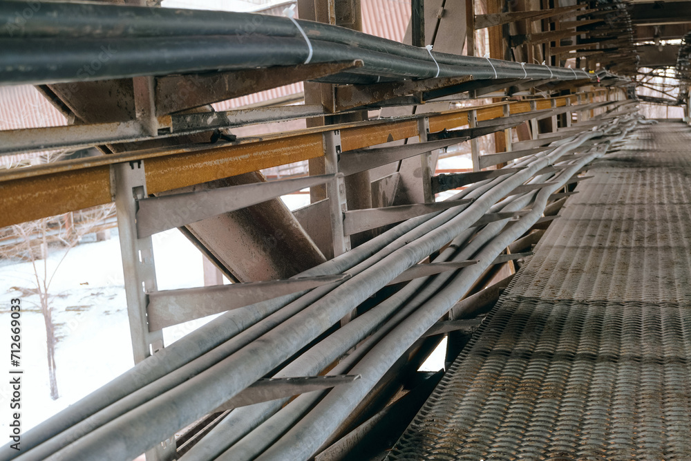 Rows of cable on a cable overpass. Outdoors industrial conduit corridor ...