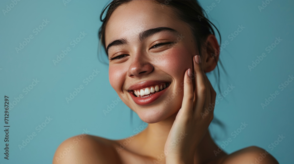 Smiling woman with a hand gently touching her face, displaying clear ...