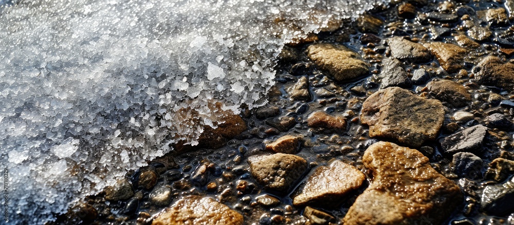 Salt grains on icy sidewalk pavin slab with rock salt in winter season ...