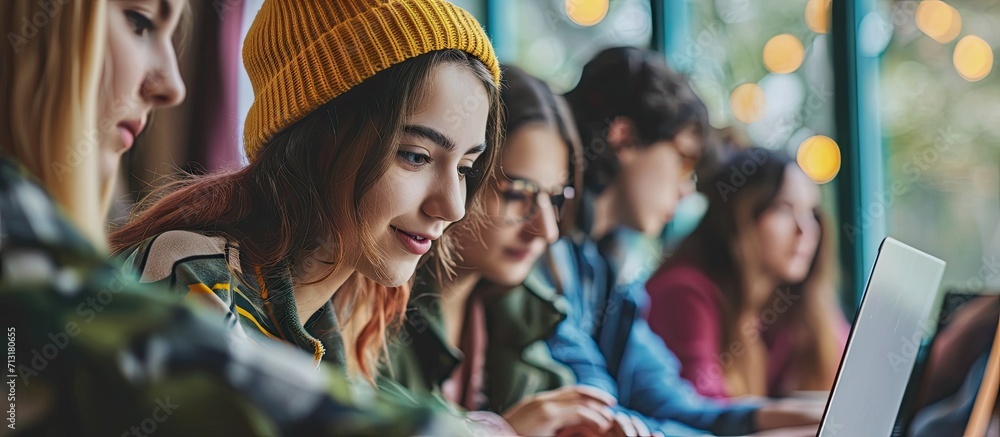 Girl student explaining presentation on laptop to classmates in college ...