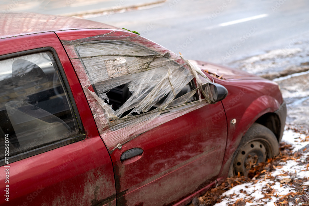 old abandoned rusty car smashed by looters on the street of a city in ...