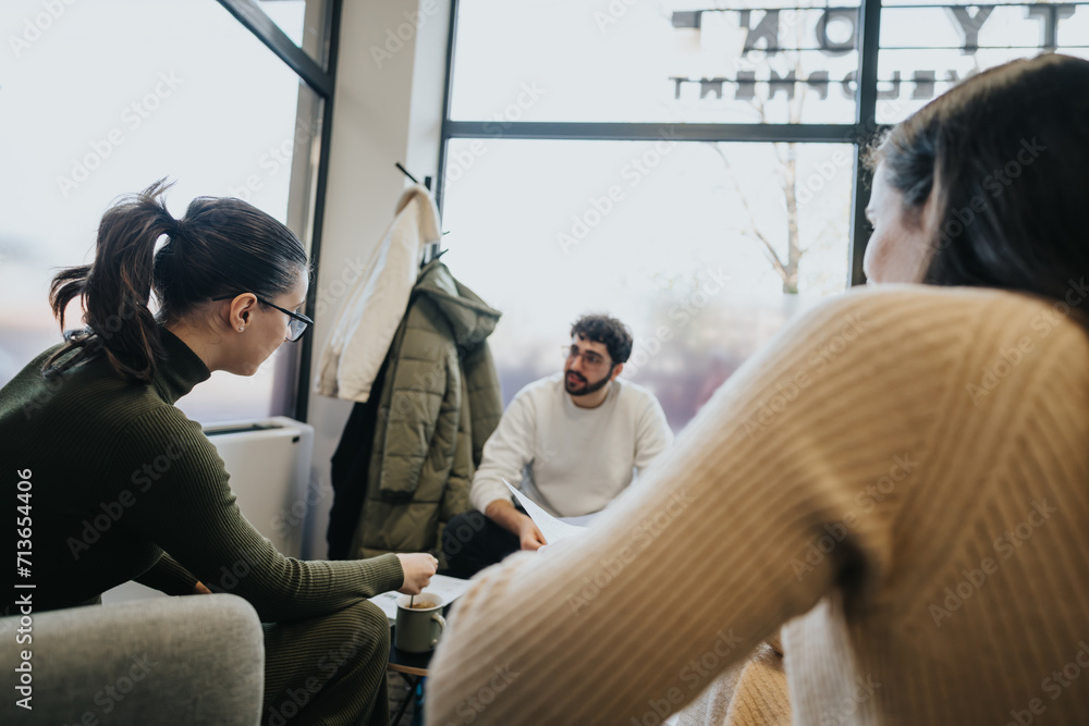Colleagues in a comfy workspace discussing ideas and collaborating for ...