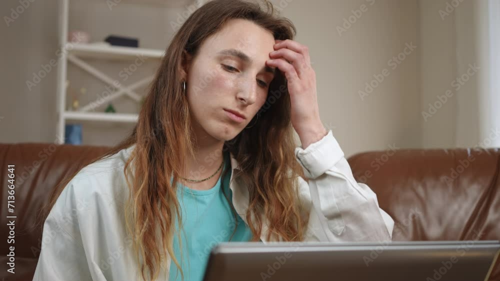 Close-up. A girl types on a laptop keyboard while sitting on a leather ...