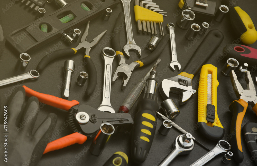 Handyman tool kit on black wooden table. Many wrenches and screwdrivers ...