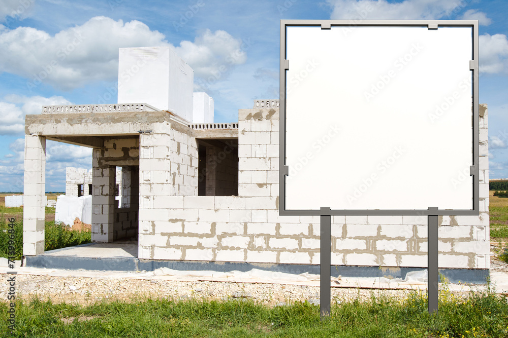 Construction of brick building. White advertising sign. Signboard for ...