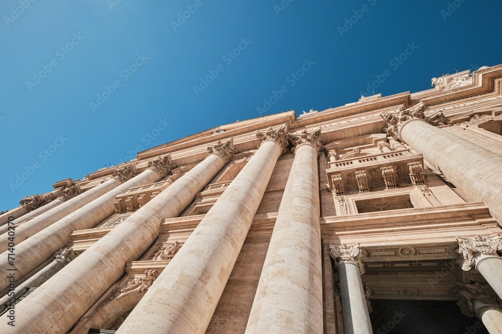 View of Saint Peter's Basilica and it's facade detail with Corinthian order columns and blue sky ...