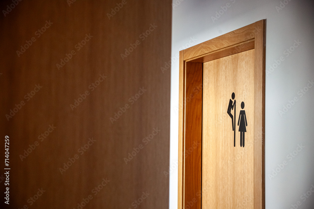 Unique restroom sign at a hotel: a man peeking over the door to the ...