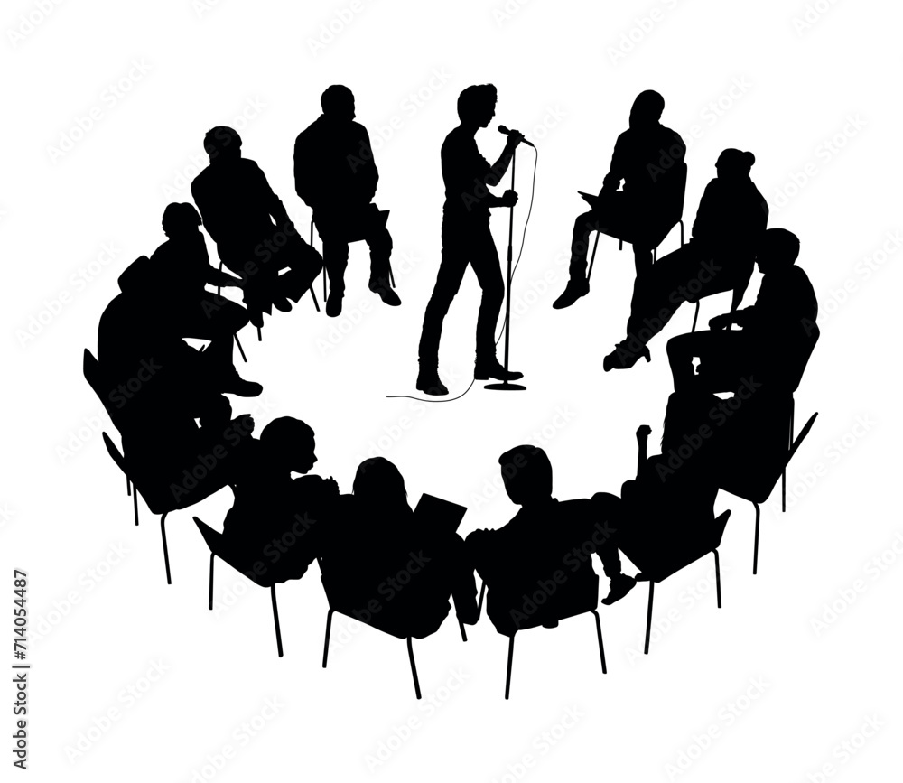 Male comedian performing stand up comedy in the middle of audience ...