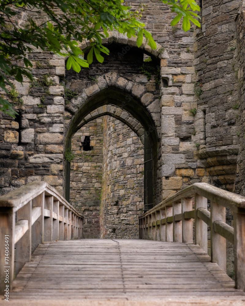 Bridge to the gatehouse and portcullis of an old stone medieval castle ...