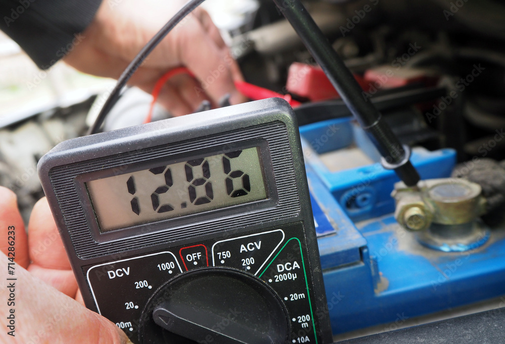 Checking vehicle battery voltage. Battery charge check with voltmeter ...