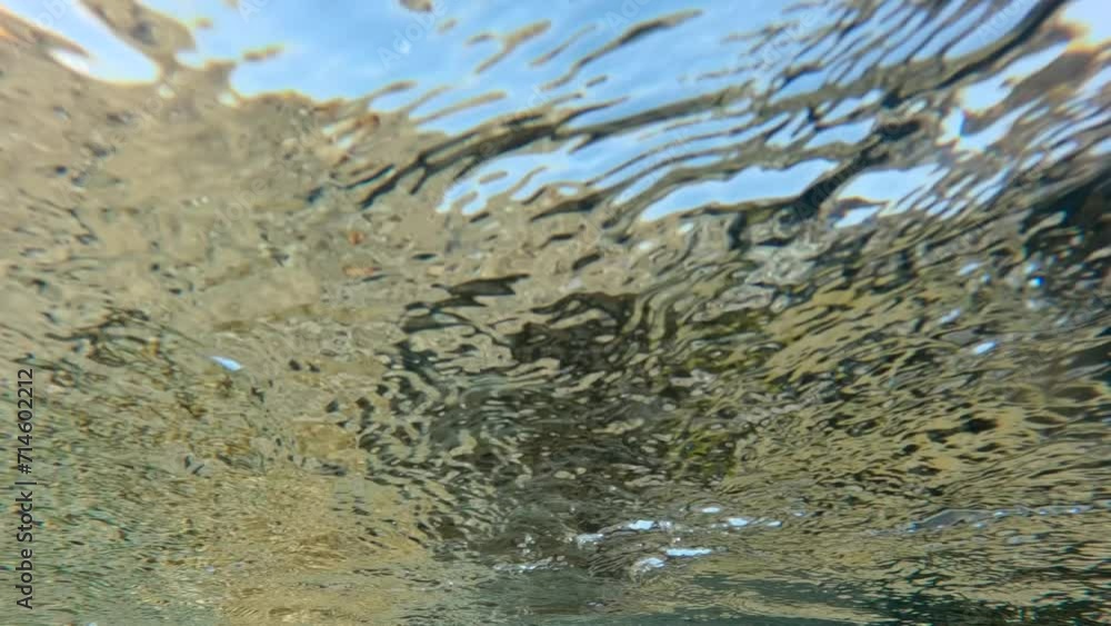 Bottom view of flowing water. Underwater view of the wavy surface of ...