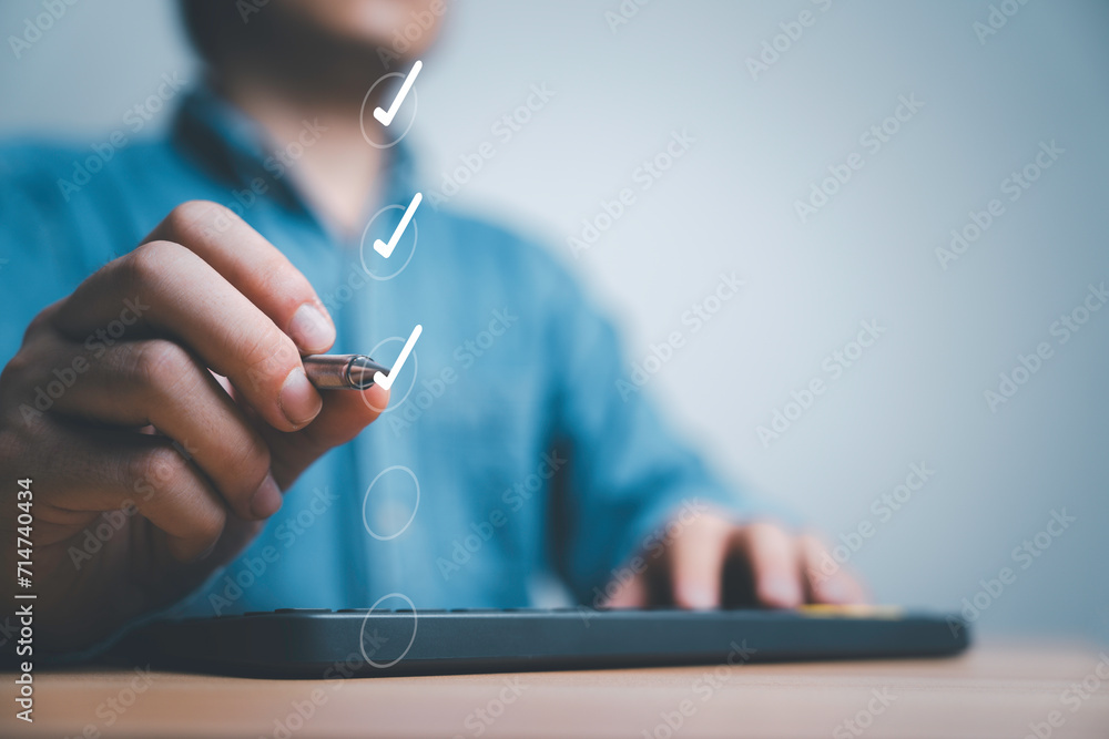 Businessman using pen tick correct sign mark on checkbox for quality ...