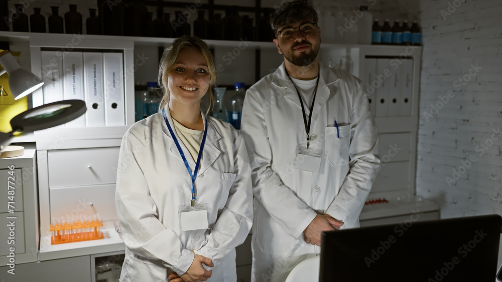 Man and woman in white lab coats are coworkers in a laboratory with ...