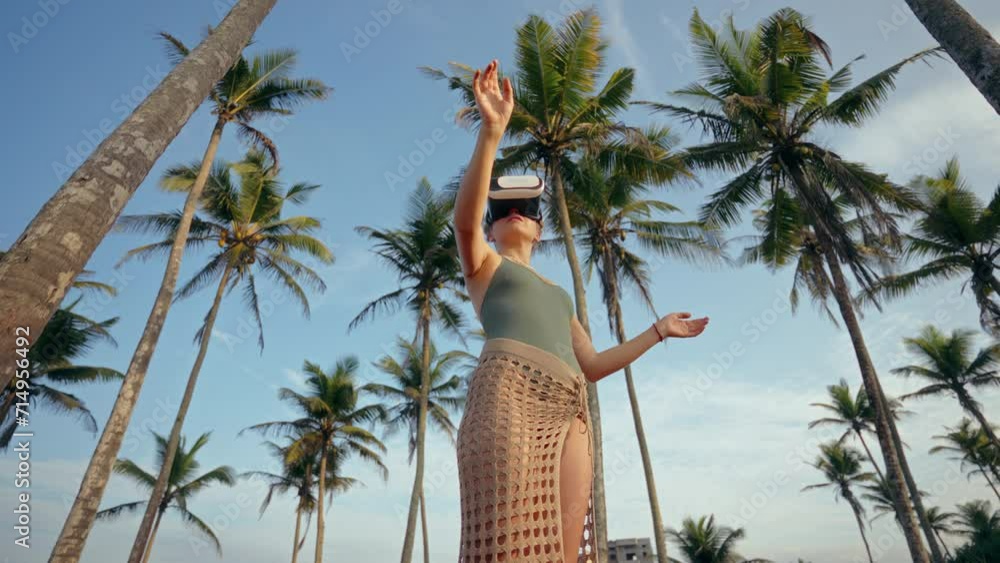 Woman in VR headset explores digital world, moves arms gracefully among ...