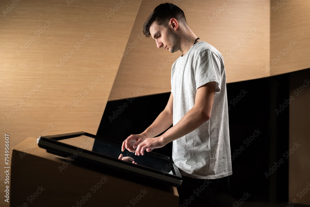 Adolescent boy making hand and finger gestures on the touch screen ...