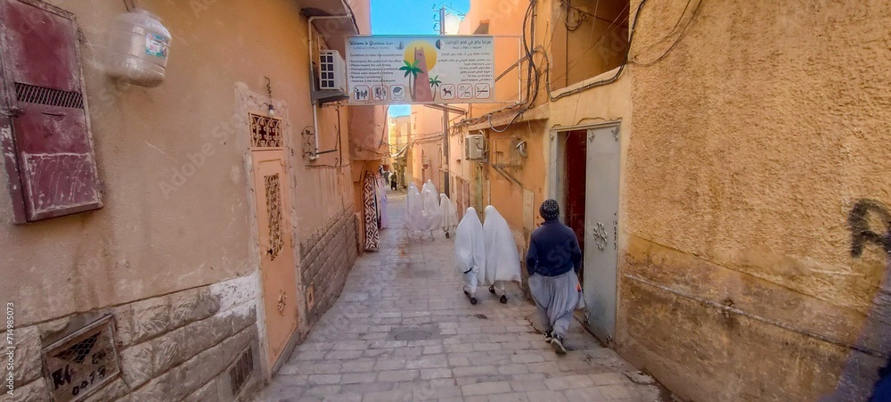 narrow alley, people wearing traditional clothes, and houses made of ...