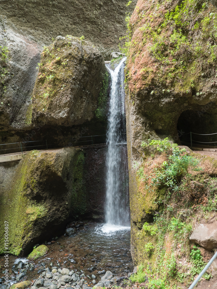 View of waterfall crossing the path at levada, water irrigation channel ...