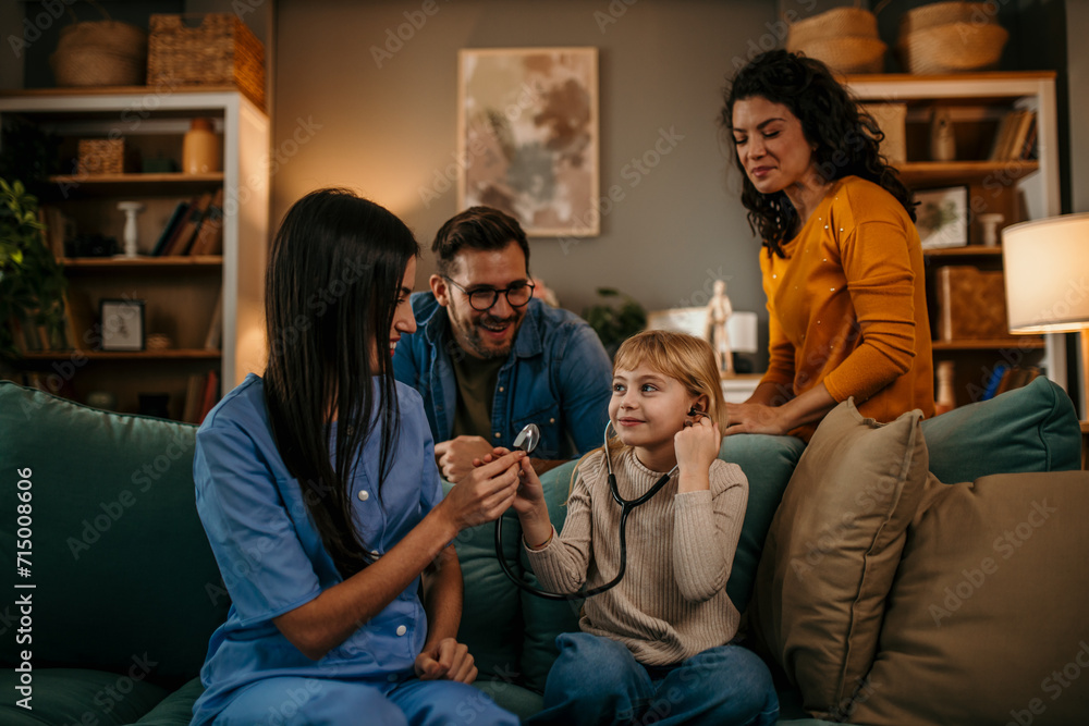 Family observes as a professional home nurse and their child share a ...