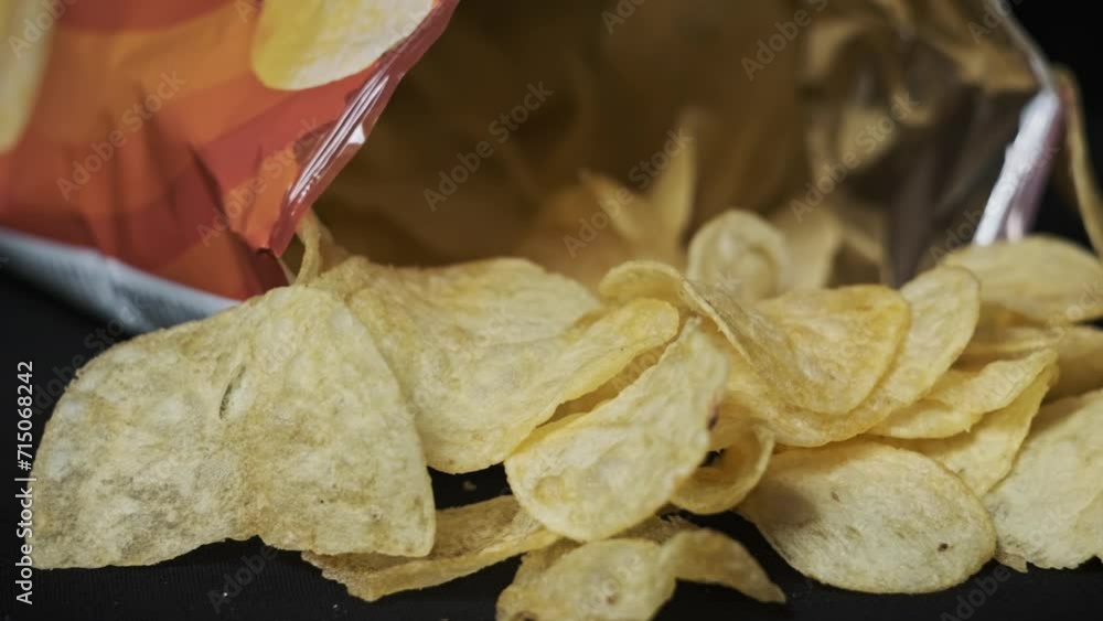 Vidéo Stock An open chips pack rotates on a black background close-up ...