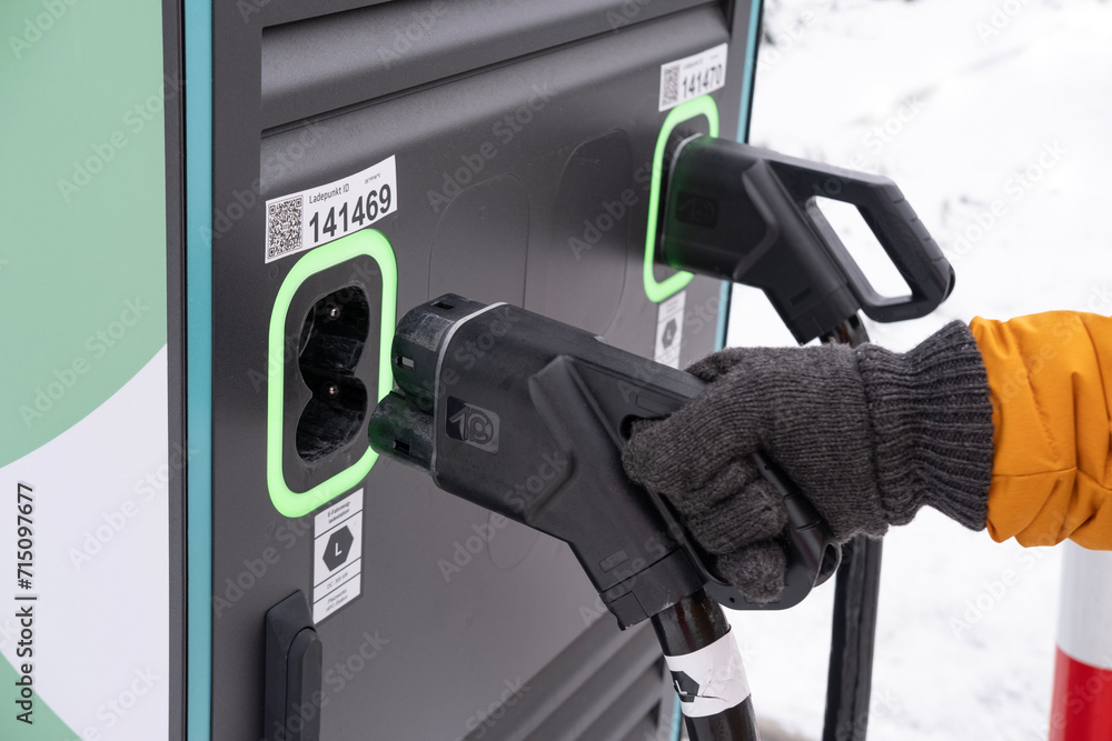 man holding DC charging connector in hand, electric vehicle Combined ...