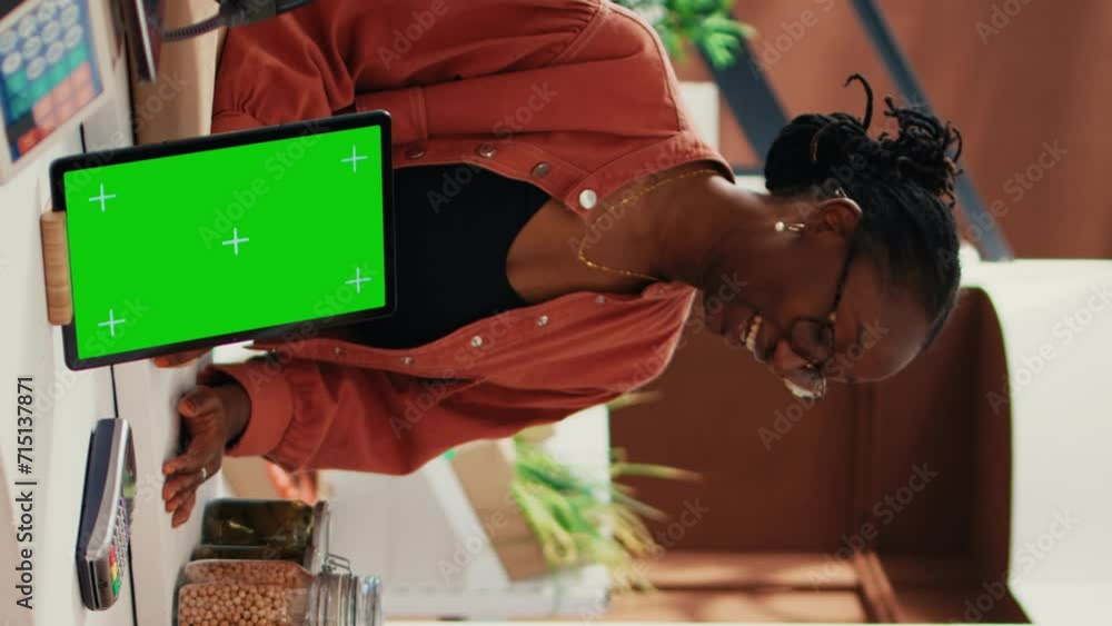 Vertical Video Woman approaching checkout with greenscreen on tablet ...