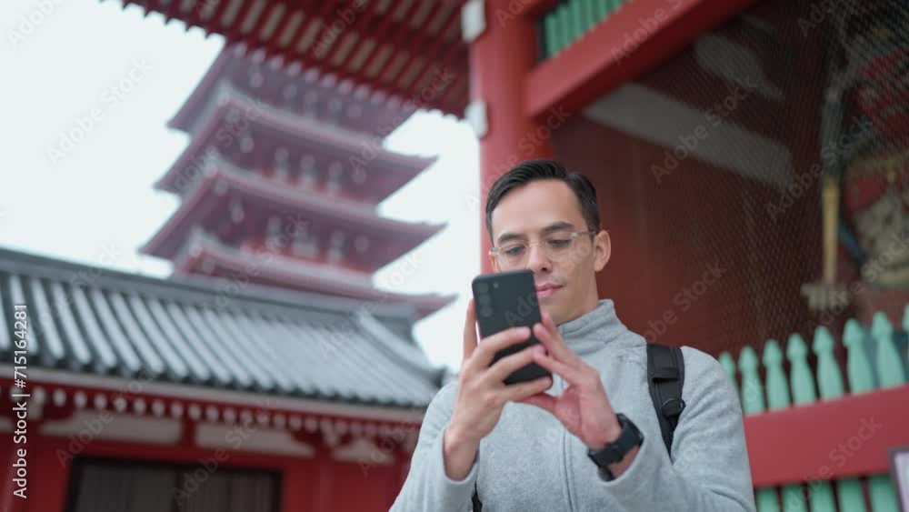 Hispanic tourist guy standing on blurred background of Japanese temple ...